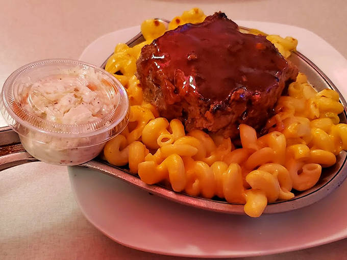 That meatloaf isn't floating on a sea of mac and cheese – it's proudly surfing on waves of cheesy comfort that crash right into your soul.