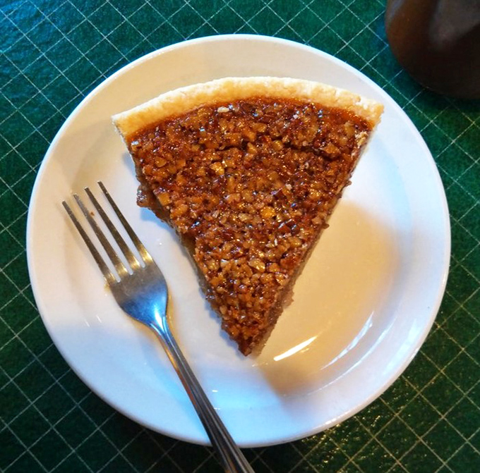 Amber-hued and glistening with sweetness, this pecan pie showcases perfectly arranged nuts atop a filling that strikes the ideal balance between gooey and firm.