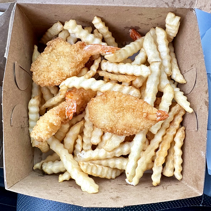 Crispy golden shrimp nestled among crinkle-cut fries &ndash; seafood and potatoes in perfect harmony, no fancy sauce needed.