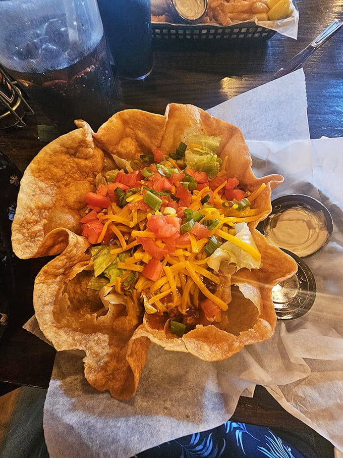 The taco salad arrives in an edible shell fortress, loaded with fresh toppings that transform a simple salad into a fiesta.