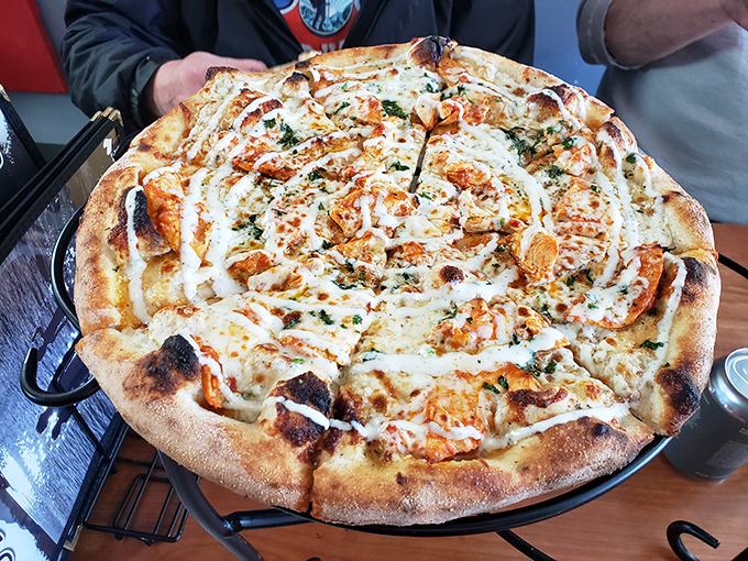 Buffalo chicken pizza close-up reveals the artful drizzle of ranch that ties all the flavors together beautifully.
