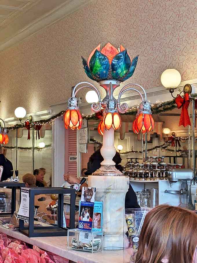 Vintage Tiffany-style lamps cast a warm glow throughout the parlor, creating an atmosphere that feels like stepping into a colorful storybook.