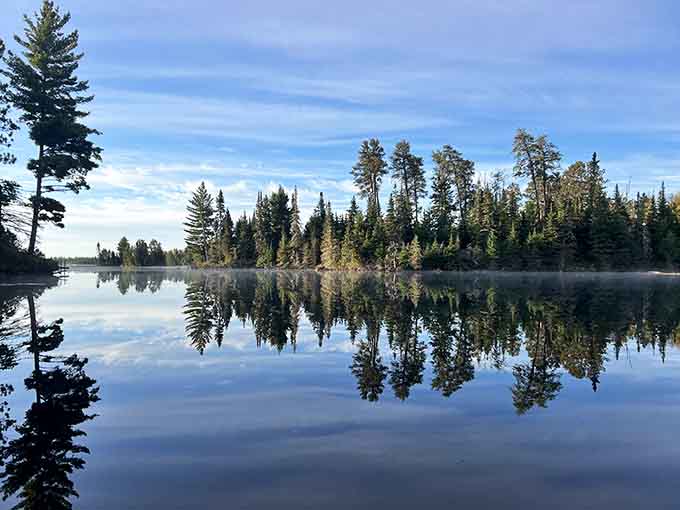 Morning mist rises off the water like the lake is exhaling, creating reflections so perfect they'll make you question which way is up.
