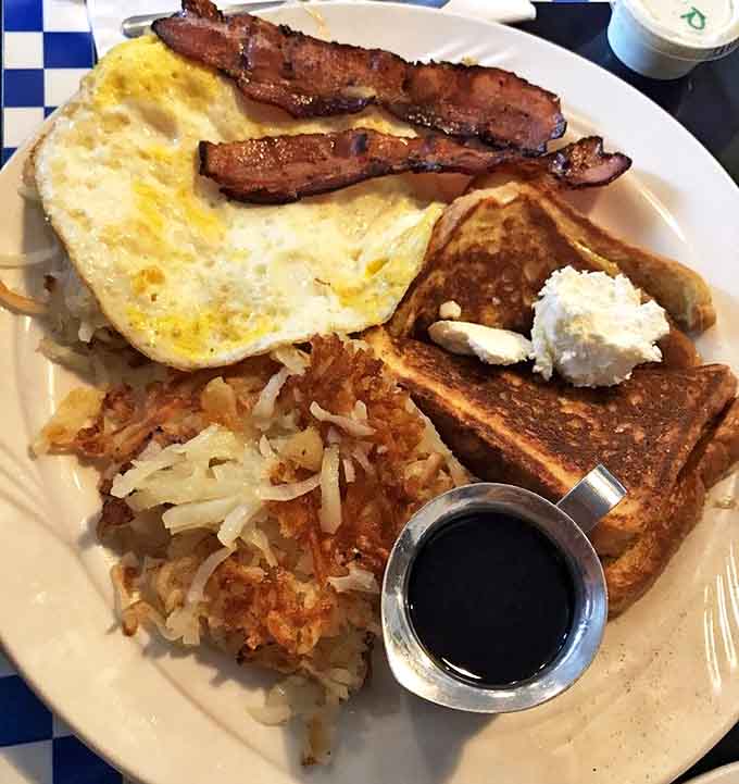 The classic American breakfast in all its glory &ndash; eggs, bacon, toast, and hash browns arranged like old friends on a plate.