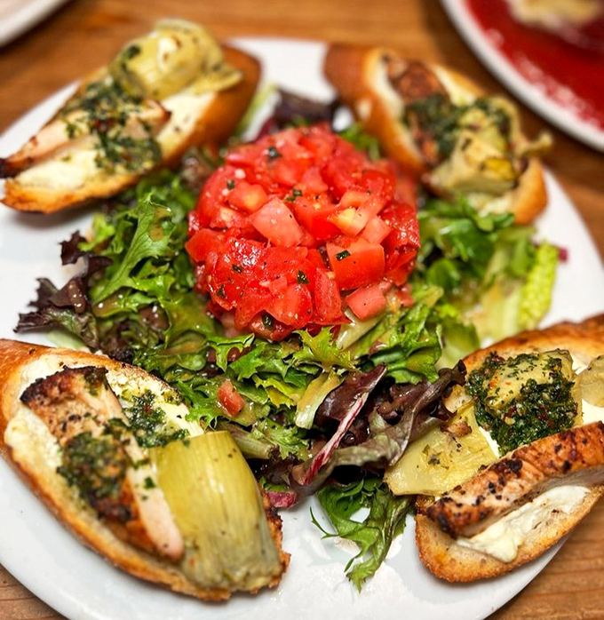 Crisp bruschetta and fresh tomatoes brighten the plate with bold flavors and vibrant summer freshness.