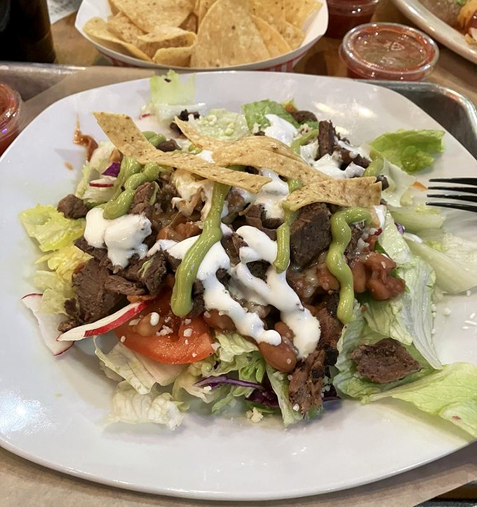 A taco salad that makes other salads jealous – crisp lettuce, seasoned beef, and a shower of toppings that turn "eating healthy" into a fiesta.
