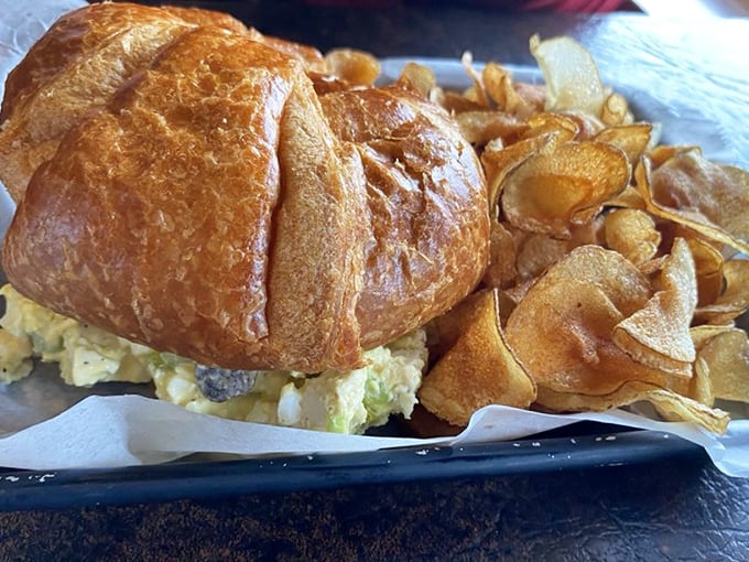 The chicken salad croissant sandwich pairs buttery, flaky pastry with creamy filling, served alongside house-made chips that shatter satisfyingly with each bite.