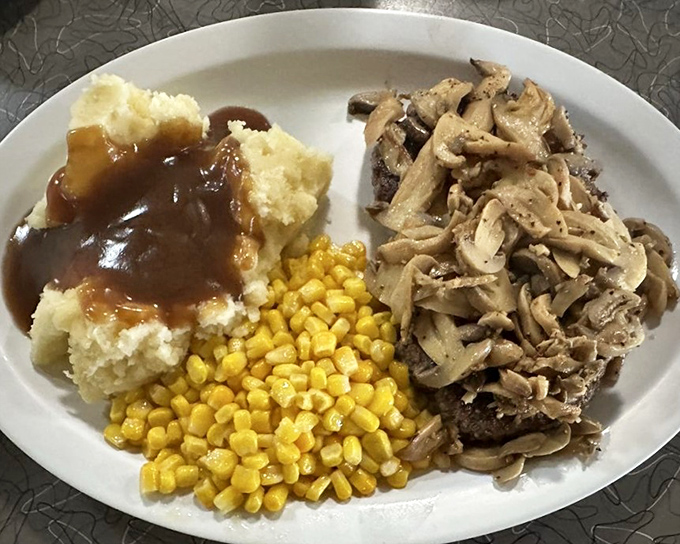 Chopped steak smothered in mushroom gravy with a side of buttery mashed potatoes – comfort food that speaks a universal language.
