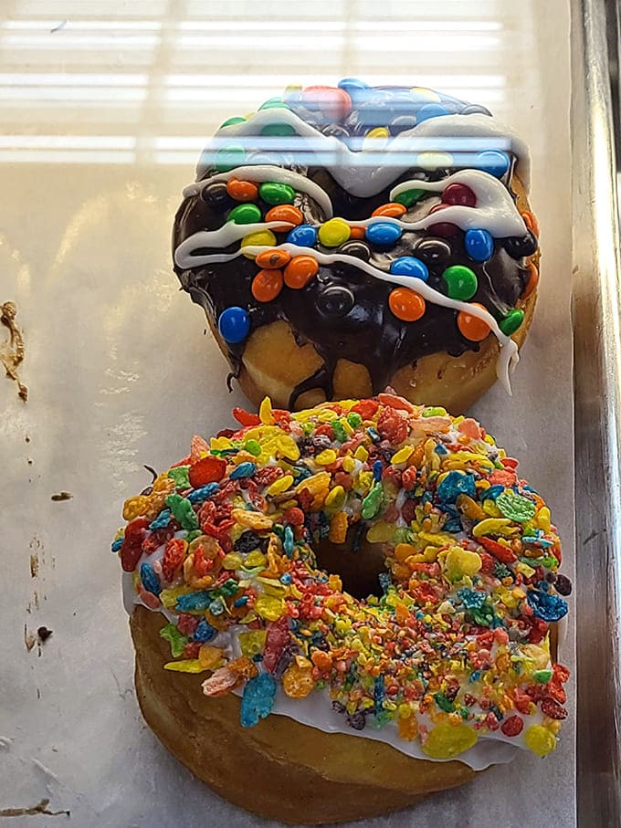 Donuts that look like they raided a candy store &ndash; topped with chocolate, M&Ms, and Fruity Pebbles, they're childhood dreams in edible form.