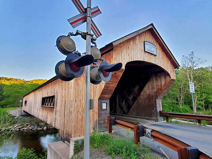 The covered bridge stands as a testament to craftsmanship, railroad signals adding a touch of nostalgia to this quintessential Vermont scene.