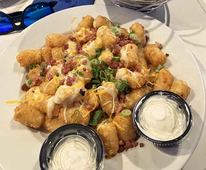 Loaded tater tots covered in cheese, bacon, and green onions represent peak Midwest snacking achievement and happiness.
