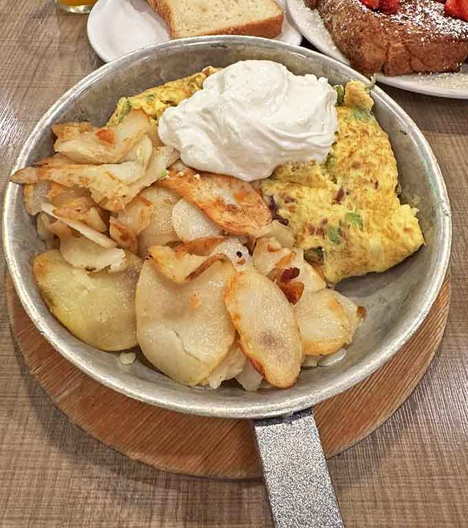 The Denver omelet arrives fluffy and generous, stuffed with ham and veggies, accompanied by those legendary crispy hash browns.