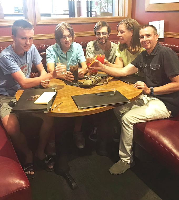 Friends toast to good times around a circular table &ndash; at Schwarz's, every meal feels like a celebration worth remembering.