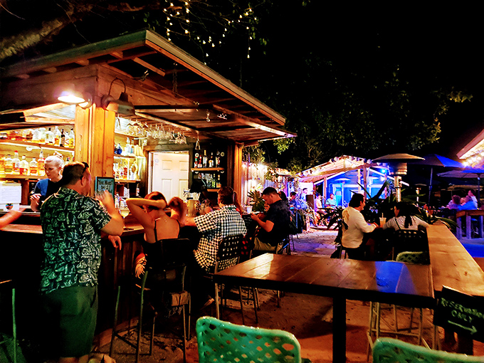As night falls, the outdoor bar becomes a gathering spot where locals and visitors share stories under twinkling lights.