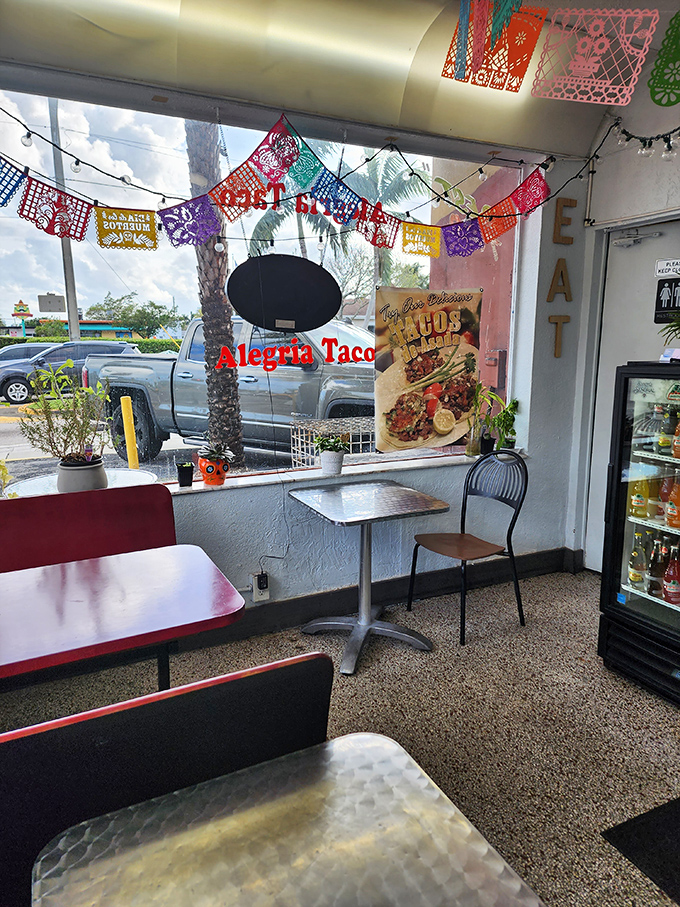 Minimalist charm defines this intimate space where colorful banners and natural light create an atmosphere as authentic as the food.