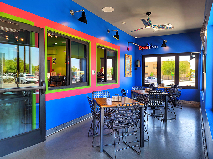 Electric blue walls and hot pink window frames create a dining space that's as bold as the flavors coming from the kitchen.