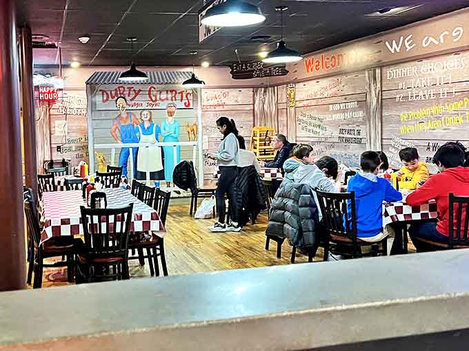 Families gather around checkered tables while the walls share decades of diner wisdom and delightfully quirky humor.