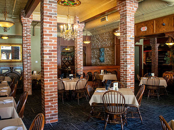 Windsor chairs and white tablecloths create an atmosphere where chandeliers cast a golden glow over conversations and culinary delights.