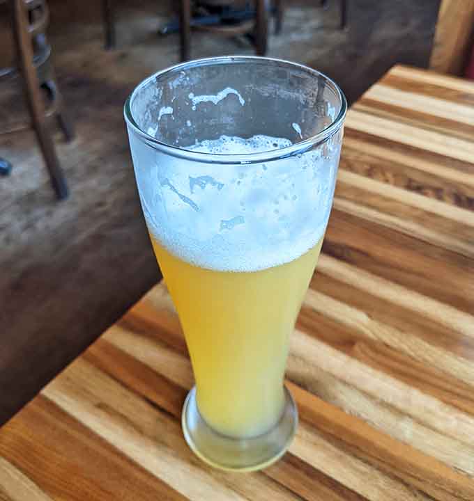 A perfectly poured pint catches the light, ready to accompany whatever delicious decision you've made from the menu.