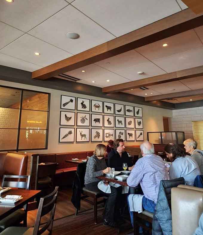 Happy diners enjoy their meals beneath whimsical animal artwork, creating a relaxed atmosphere that encourages lingering over dessert.