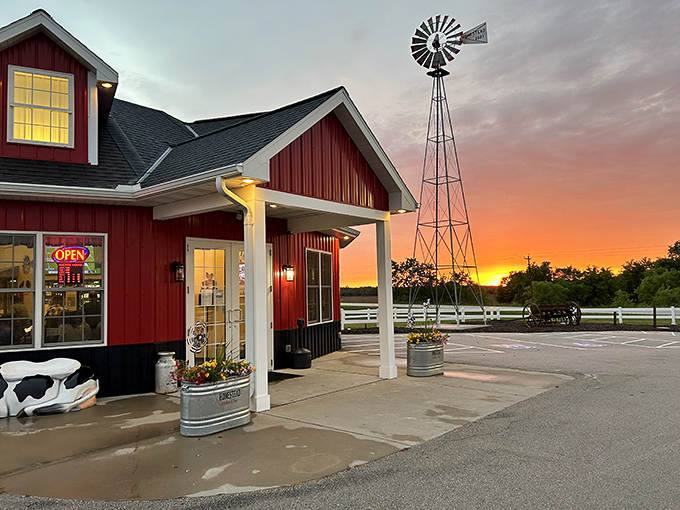Homestead Kitchen & Tap glows warmly against a spectacular sunset, where the silhouetted windmill stands as a nod to Wisconsin's farming heritage.