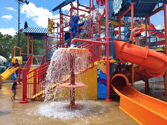Water cascades from every angle in this colorful play structure, where getting soaked isn't just expected &ndash; it's the whole point.
