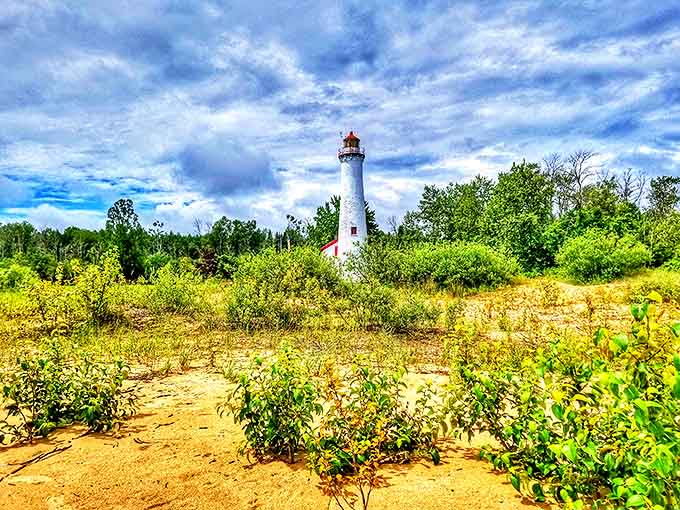 The lighthouse peeks through summer greenery, playing hide-and-seek with visitors who round the bend in the trail.