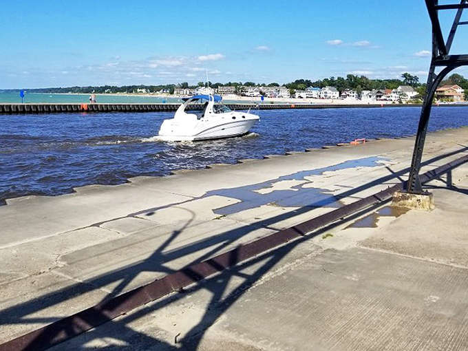 Boats glide into harbor past South Haven's pier, where concrete meets water in a daily dance choreographed by wind and waves.