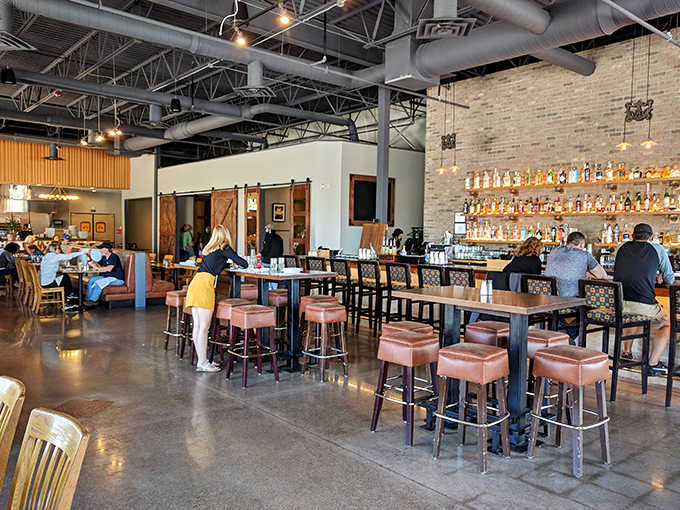 The bar area invites conversation with its warm wood tones and impressive backlit bottle display &ndash; mixology as theater.
