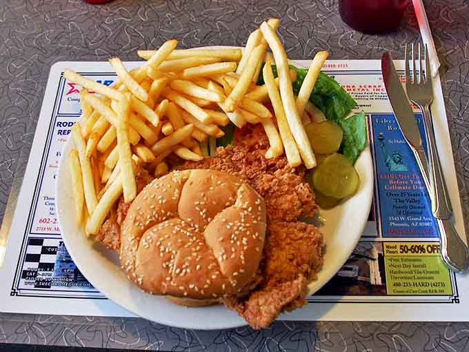 The pork loin sandwich with its crispy coating and pile of fries shows that lunch at Mel's matches breakfast for quality.