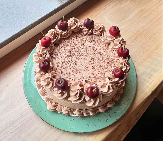 That chocolate cake topped with cherries isn't just dessert, it's the sweet finale your meal deserves, decorated with enough flair to make celebrations special.