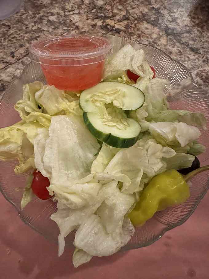 Fresh salad with pepperoncini provides a crisp, cool contrast before you dive headfirst into carbohydrate heaven without looking back.