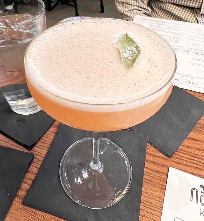 The Wisedog cocktail arrives in a copper mug with an avocado garnish, because sometimes your drink needs to be as photogenic as you are.