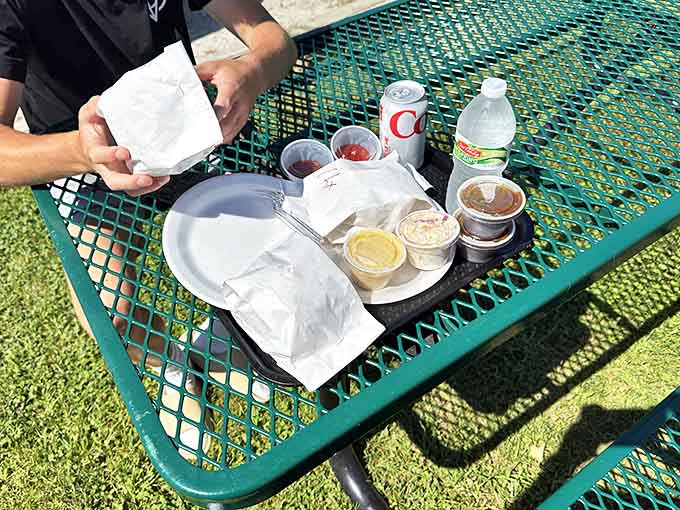 Outdoor dining at its finest, with pasties, sides, and drinks spread across a picnic table like a Michigan feast.