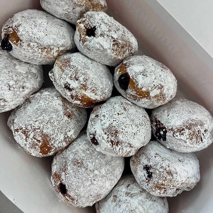 Powdered sugar-dusted jelly donuts waiting to reveal their sweet secret. One bite and you're transported to donut nirvana.