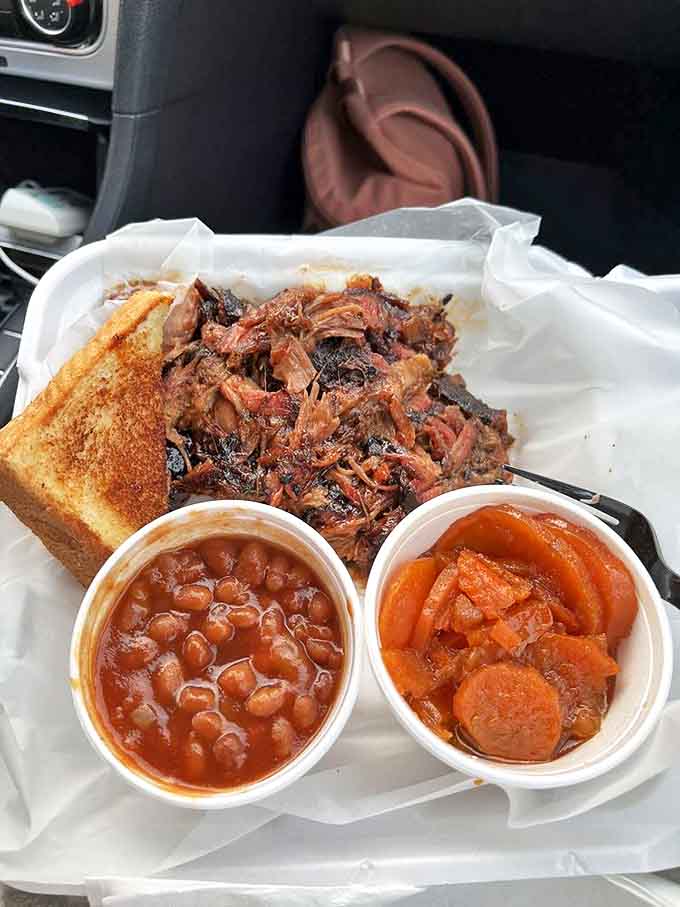 A takeout feast featuring pulled pork, beans, and candied yams &ndash; proof that barbecue travels well from Smokin' Notes to your car.