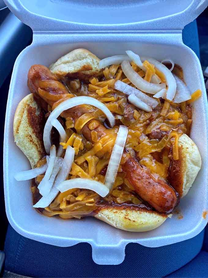The chili cheese dog gets dressed up with onions and enough toppings to require structural engineering expertise to eat properly.