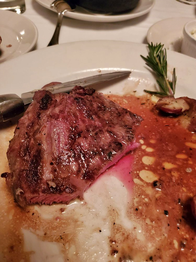 The ribeye steak sits like a king on its decorative plate, the pat of herb butter slowly creating a sauce that's liquid gold.