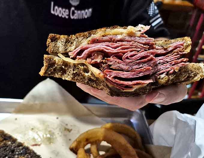This isn't just a sandwich; it's an architectural marvel of perfectly stacked corned beef that somehow maintains structural integrity until the last bite.
