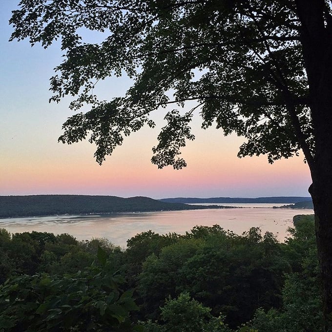 Mother Nature's watercolor hour paints the sky in impossible pinks and purples, reflecting off Glen Lake like it's showing off for the camera.