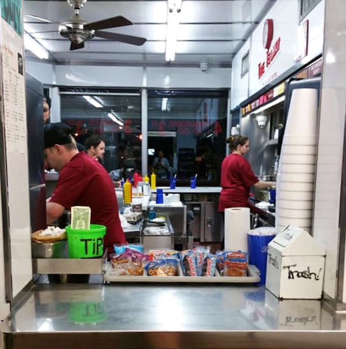 Behind the counter, the choreography of short-order cooking unfolds, a ballet of efficiency that's been perfected over countless thousands of burgers.