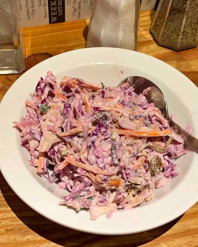 Fresh coleslaw adding crunch and color, because even fish and chips joints know vegetables exist, technically speaking.
