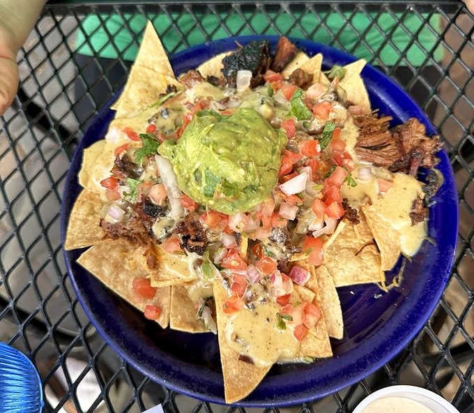Architecture meets appetite in this towering creation where tortilla chips support smoky meat, fresh pico, and that perfect guacamole crown.