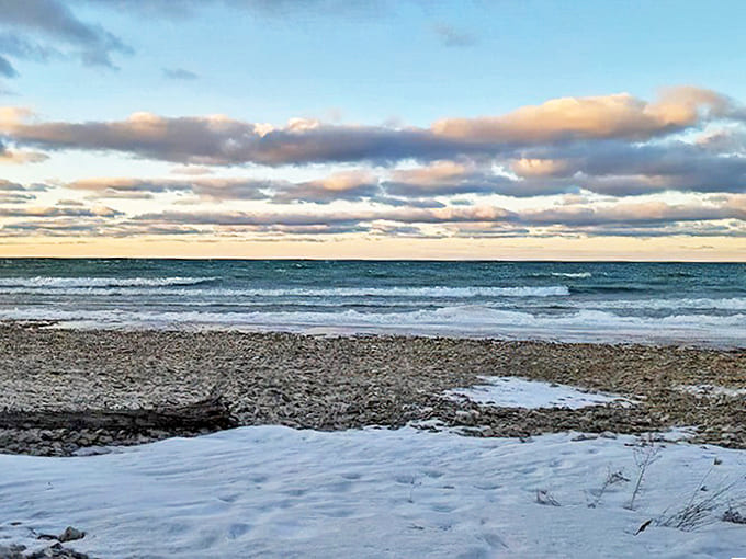 Winter waves crash against the icy shore, proving Thompson's Harbor's wild beauty knows no off-season.