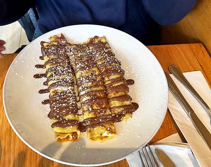 These crepes aren't just breakfast; they're dessert with morning privileges, drizzled with chocolate and dusted with powdered sugar for maximum indulgence.