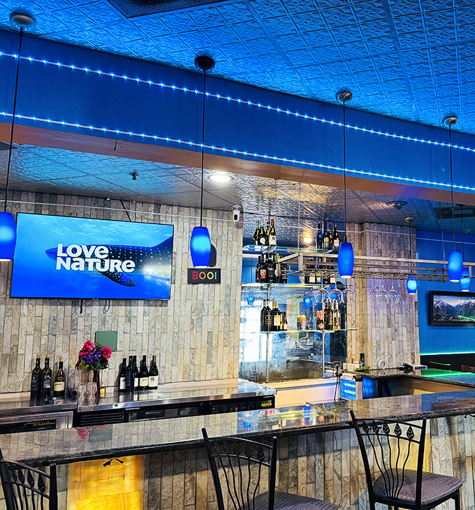 The bar area glows with blue ambiance &ndash; where traditional flavors meet contemporary vibes for pre-dinner cocktails or post-meal unwinding.