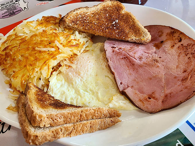 Breakfast Plate The complete morning experience &ndash; eggs, ham, hash browns and toast arranged like a delicious work of art on classic diner china.