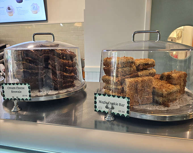 Cream cheese brownies and magic cookie bars sit under glass like edible museum pieces, tempting you to expand your dessert horizons.