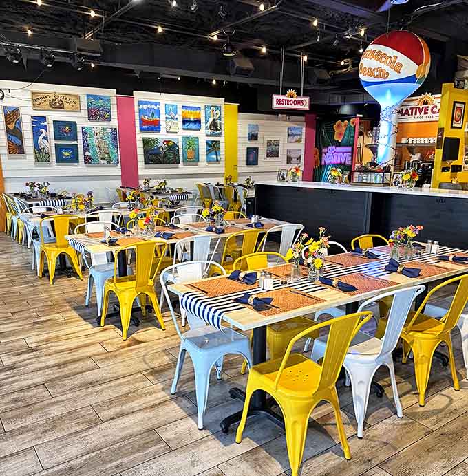 The dining area's cheerful yellow chairs and colorful accents create an atmosphere that feels like breakfast at your coolest friend's beach house.