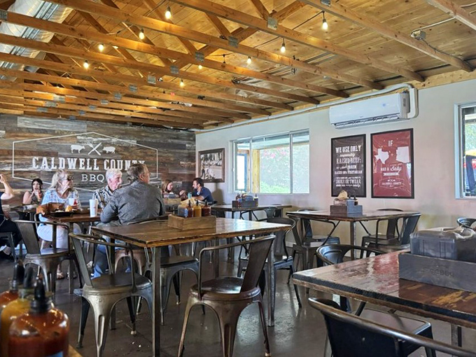 Under exposed wooden beams, diners engage in the serious business of barbecue appreciation, forks poised for the next bite of smoky perfection.
